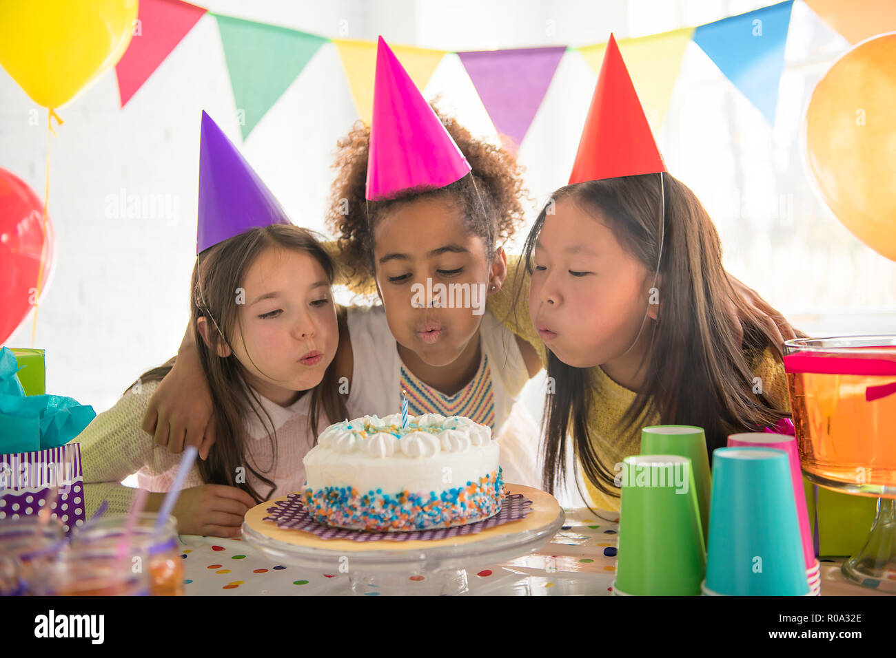 A Group of three adorable kids having fun at birthday party Stock Photo ...