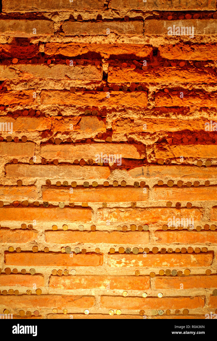 Brick wall background with coins on the bricks closeup view Stock Photo ...