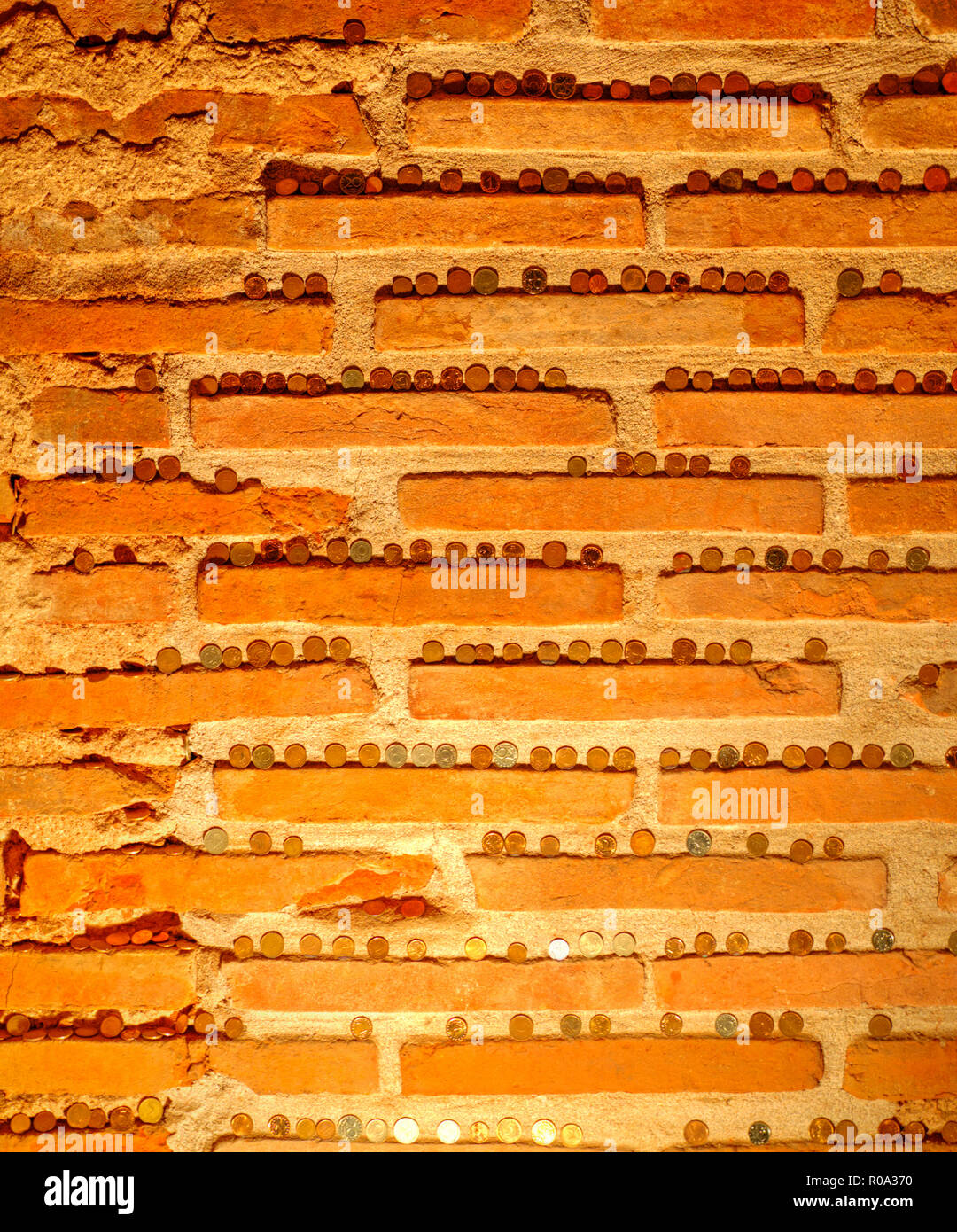 Brick wall background with coins on the bricks closeup view Stock Photo ...
