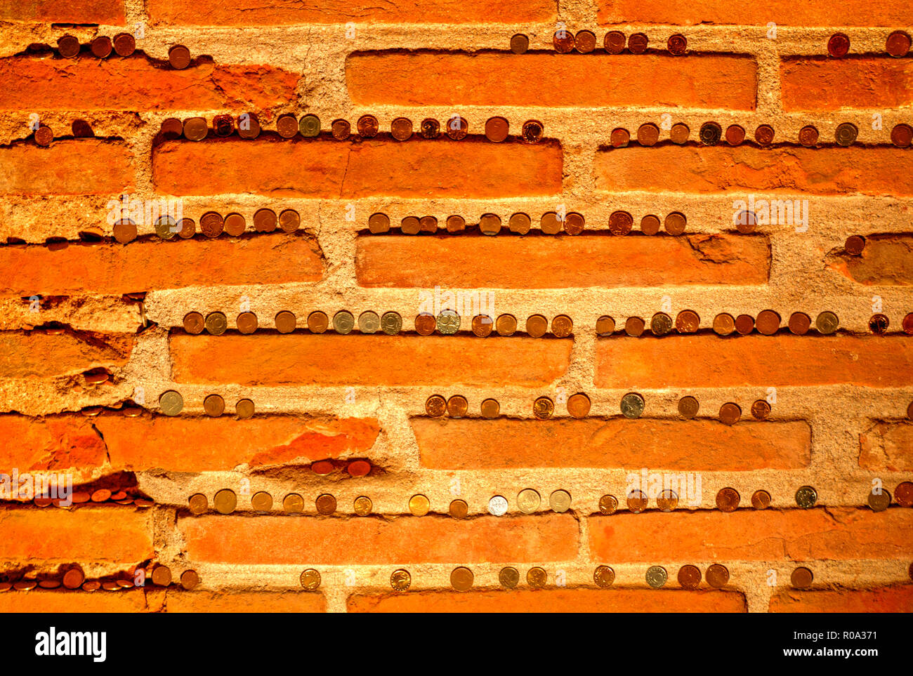 Brick wall background with coins on the bricks closeup view Stock Photo ...