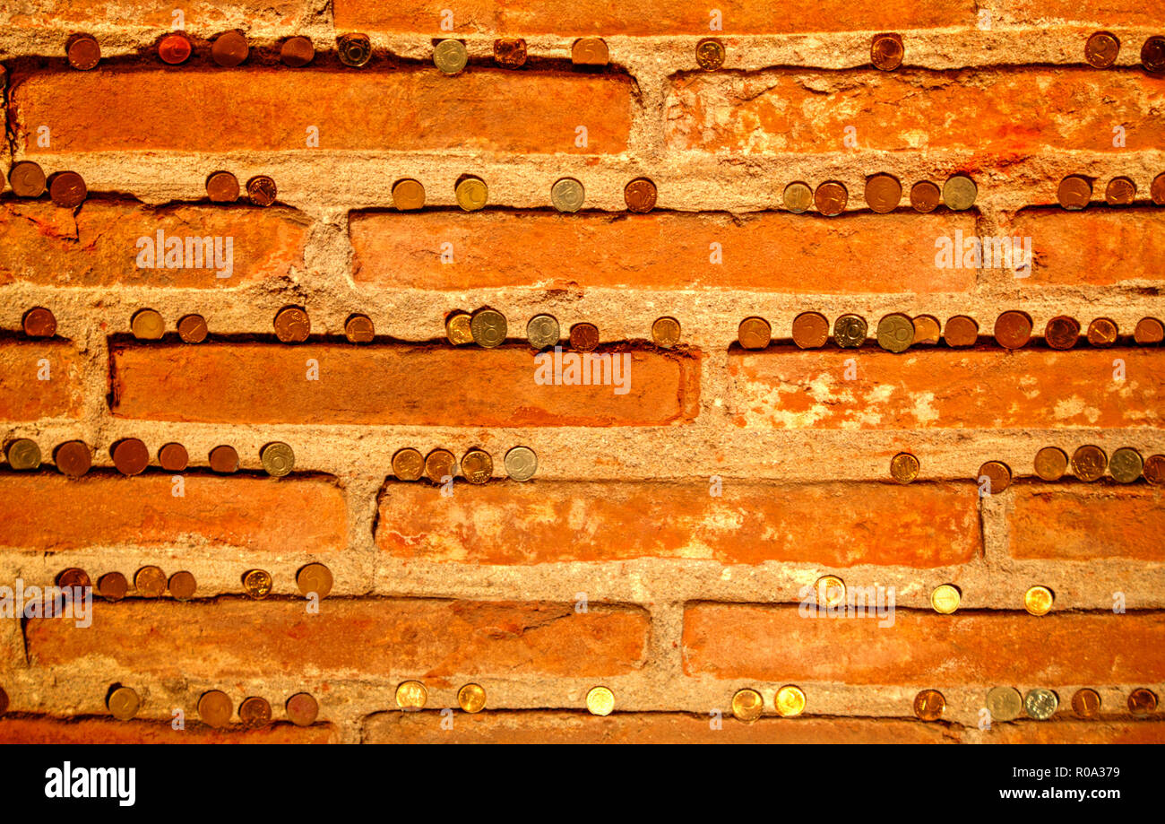 Brick wall background with coins on the bricks closeup view Stock Photo ...
