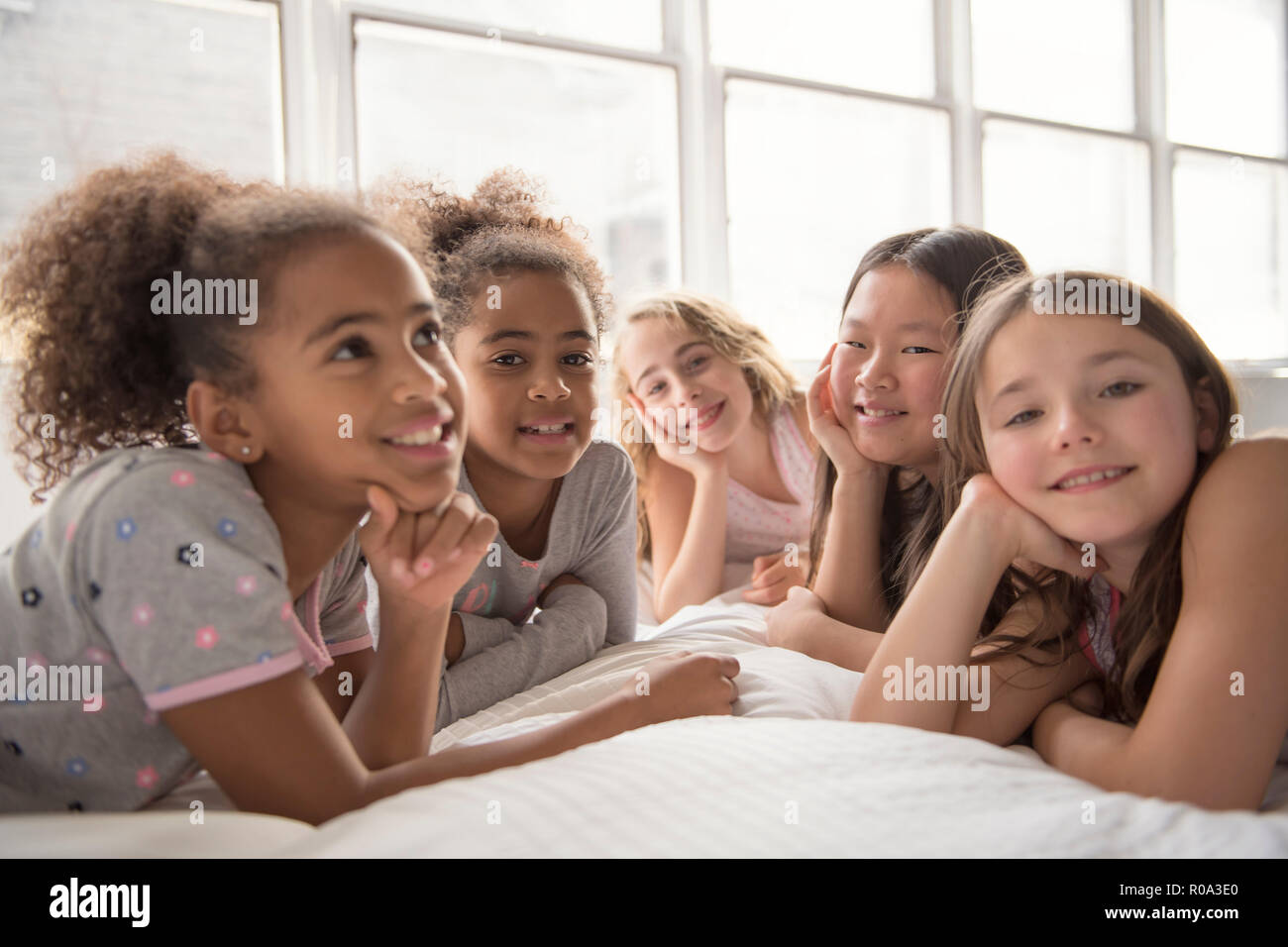 A large group of her friends taking goog time on bed Stock Photo - Alamy