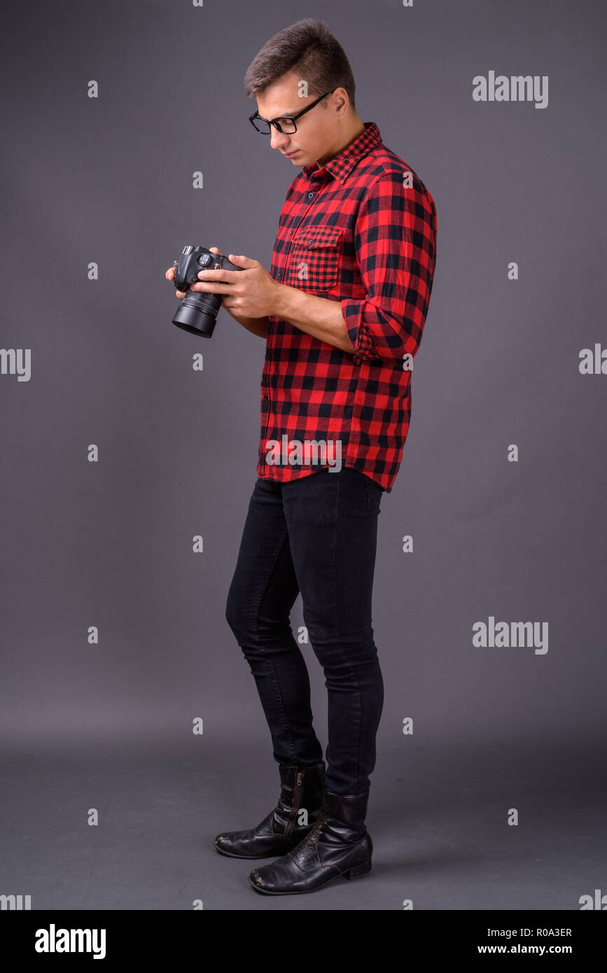 Portrait of young handsome man photographer holding camera Stock Photo ...