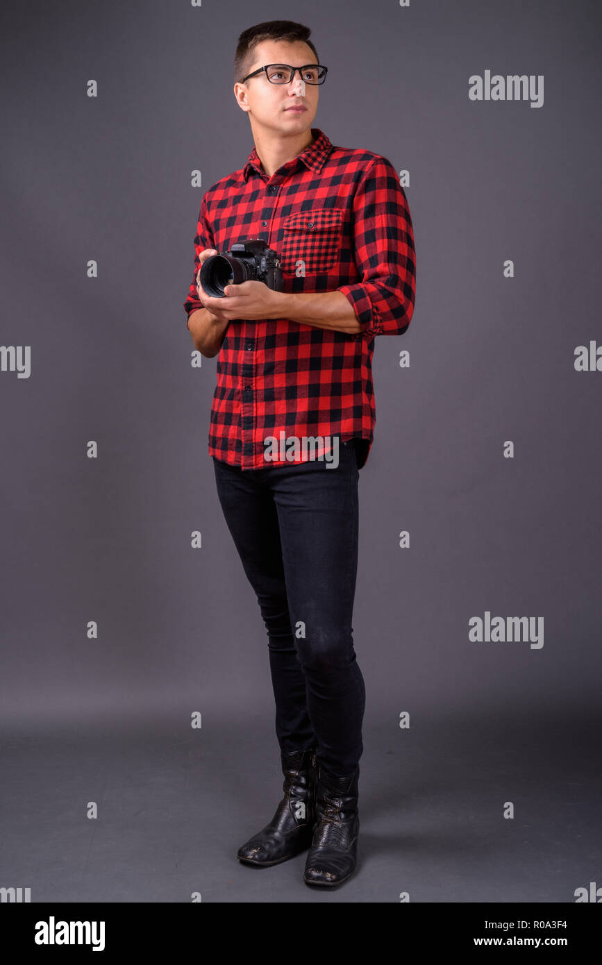 Portrait of young handsome man photographer holding camera Stock Photo ...