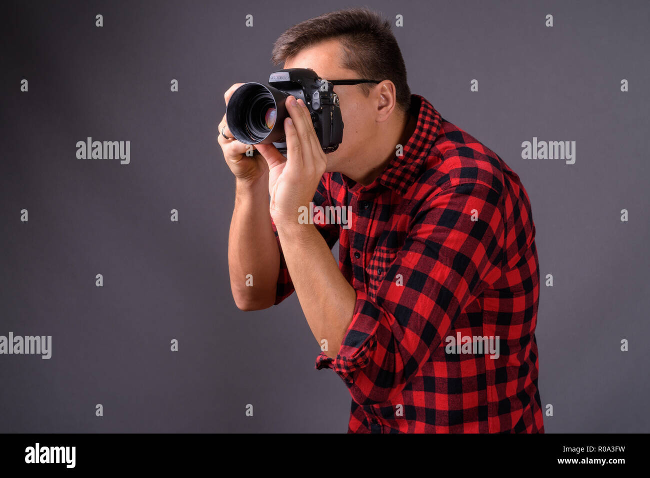 Portrait of young handsome man photographer holding camera Stock Photo ...