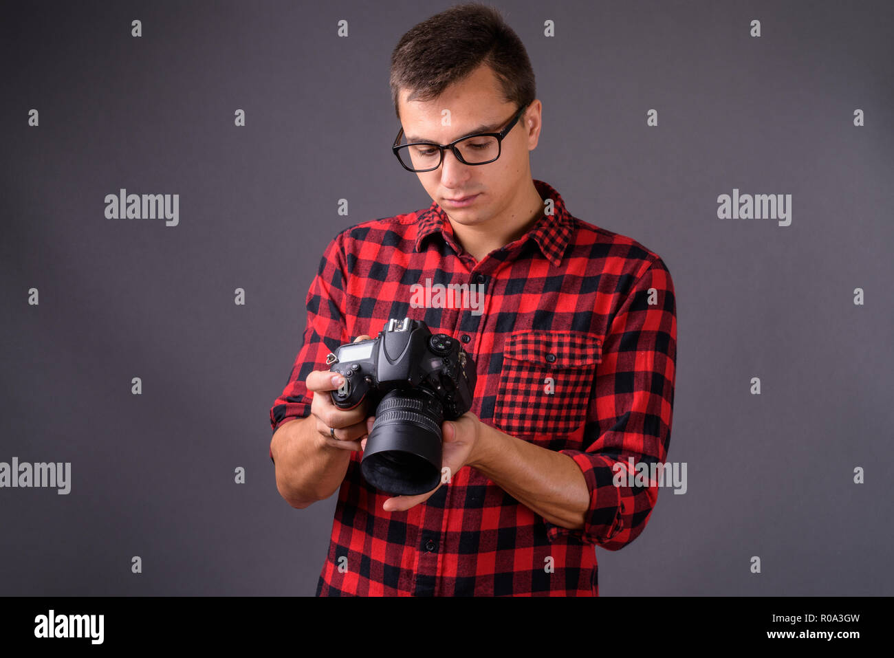 Portrait of young handsome man photographer holding camera Stock Photo ...