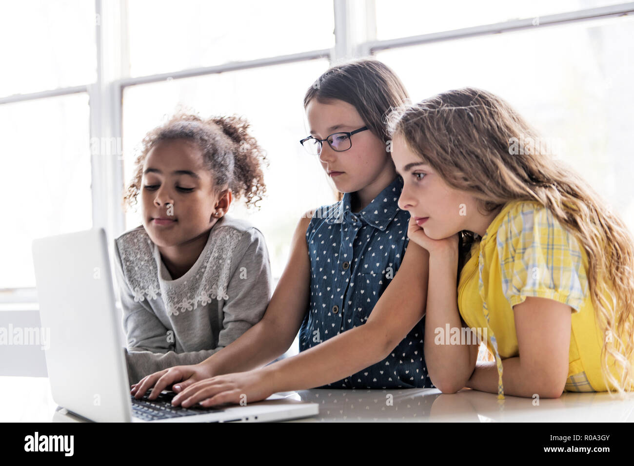A Group of curious children watching stuff on the laptop screen Stock ...