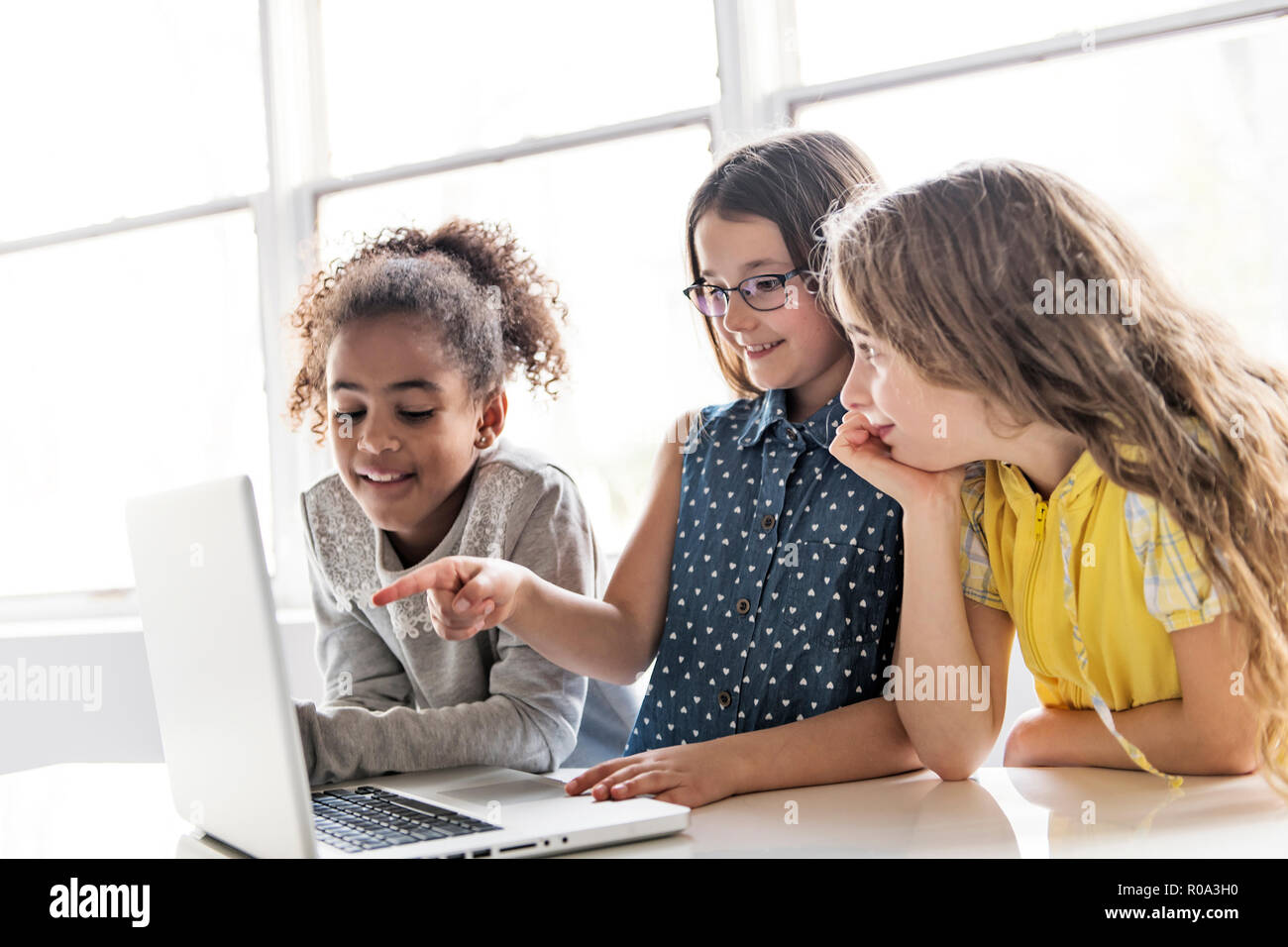 A Group of curious children watching stuff on the laptop screen Stock ...