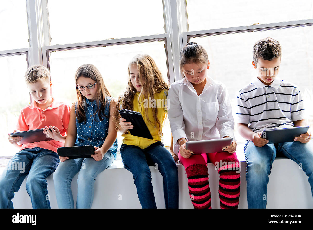 A Group of curious children watching stuff on the tablet screen Stock ...