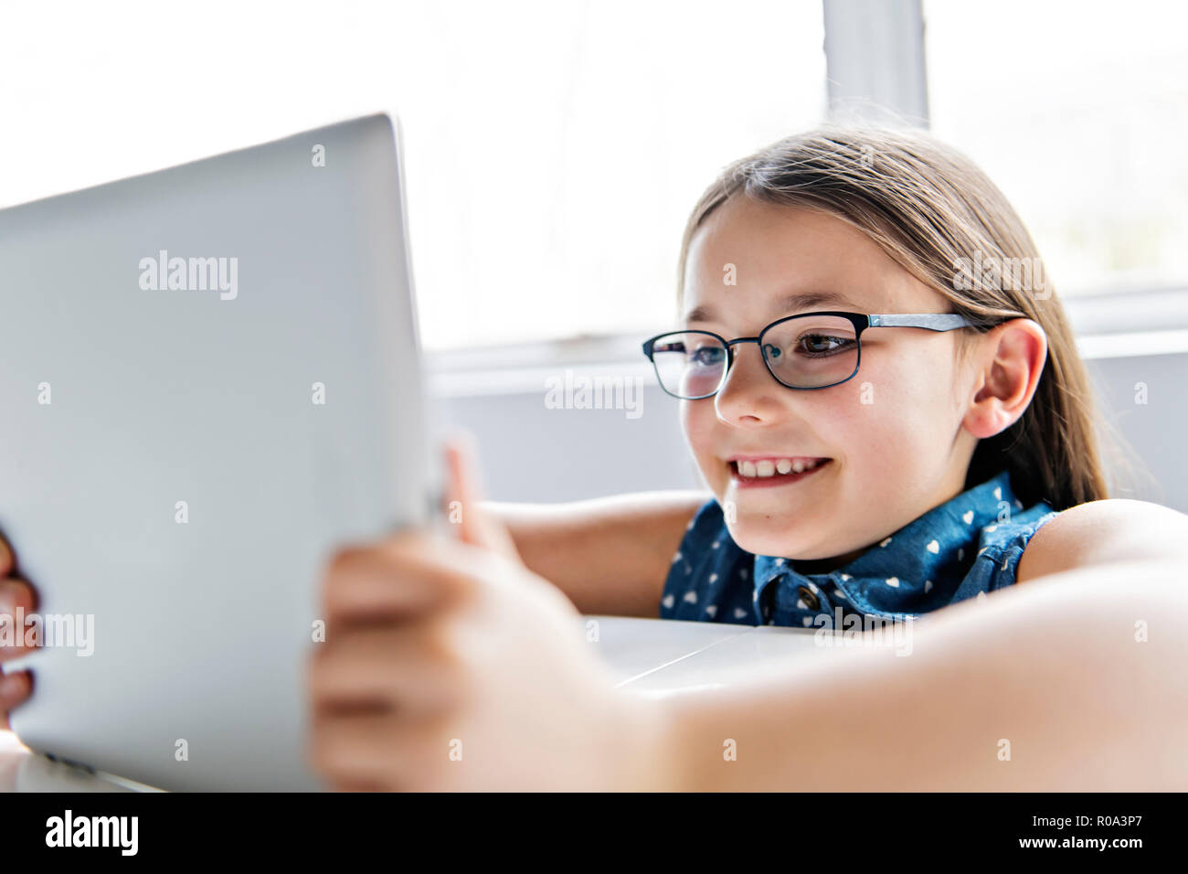 A Child using tablet at school sit at the table Stock Photo - Alamy