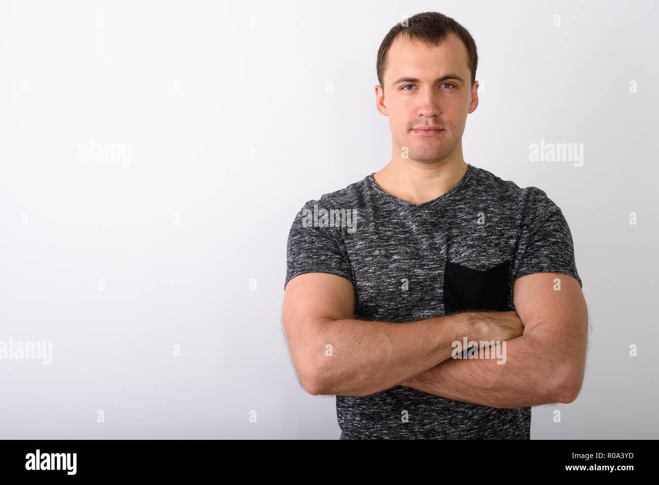 Studio shot of young muscular man with arms crossed against whit Stock ...