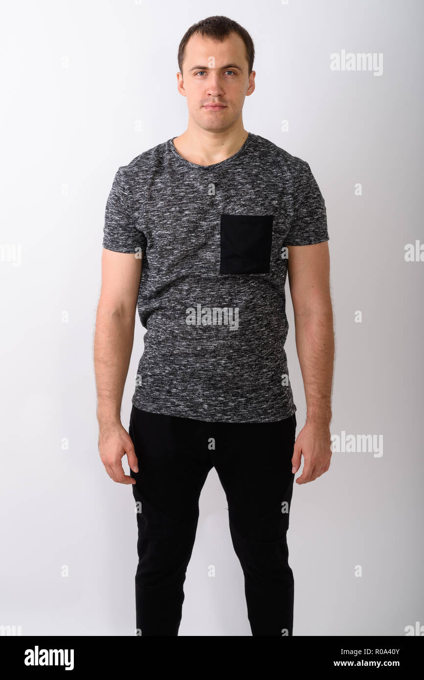Studio shot of young muscular man standing against white backgro Stock ...