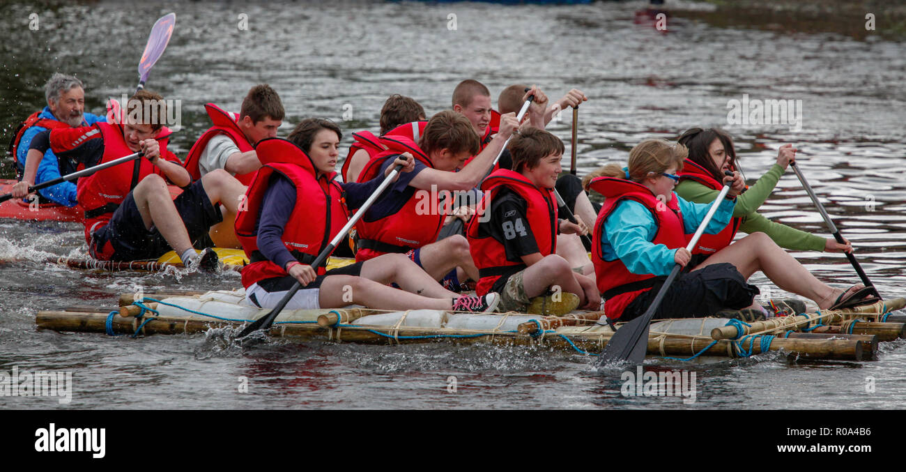 Teenage competitors paddle their home made raft towards the finish line ...