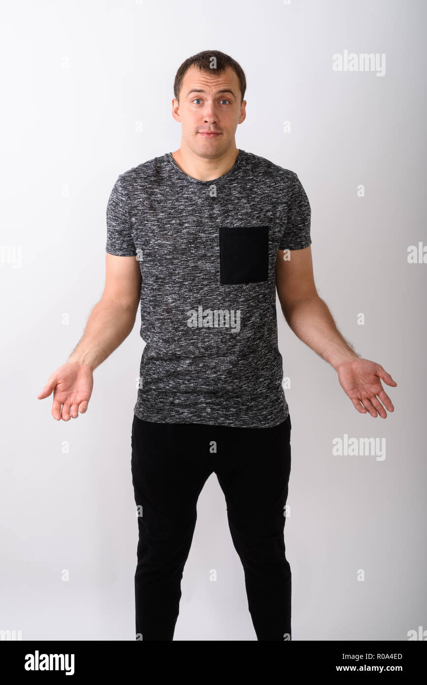 Studio shot of young muscular man standing while looking confuse Stock ...