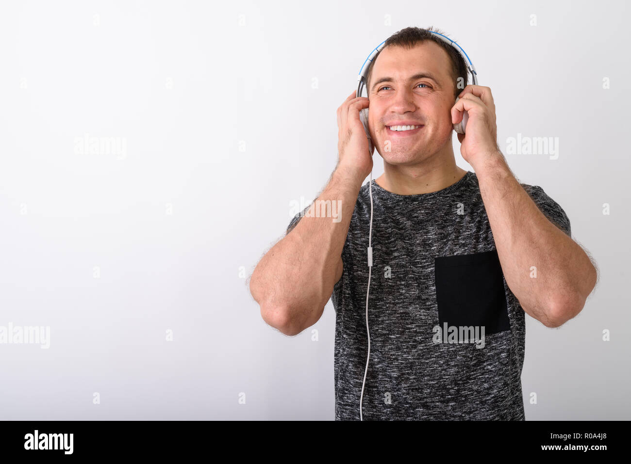 Studio shot of young happy muscular man smiling while thinking a Stock ...
