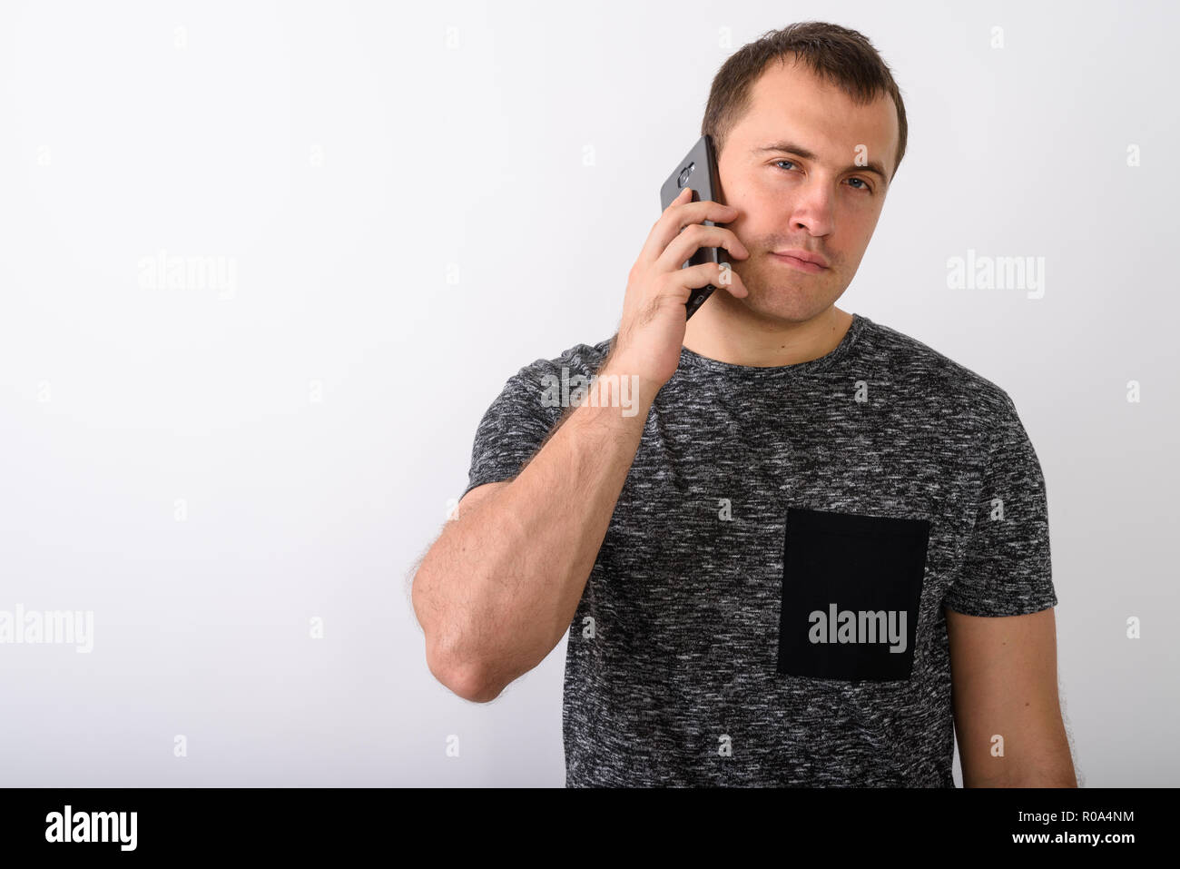 Studio shot of young muscular man talking on mobile phone agains Stock ...