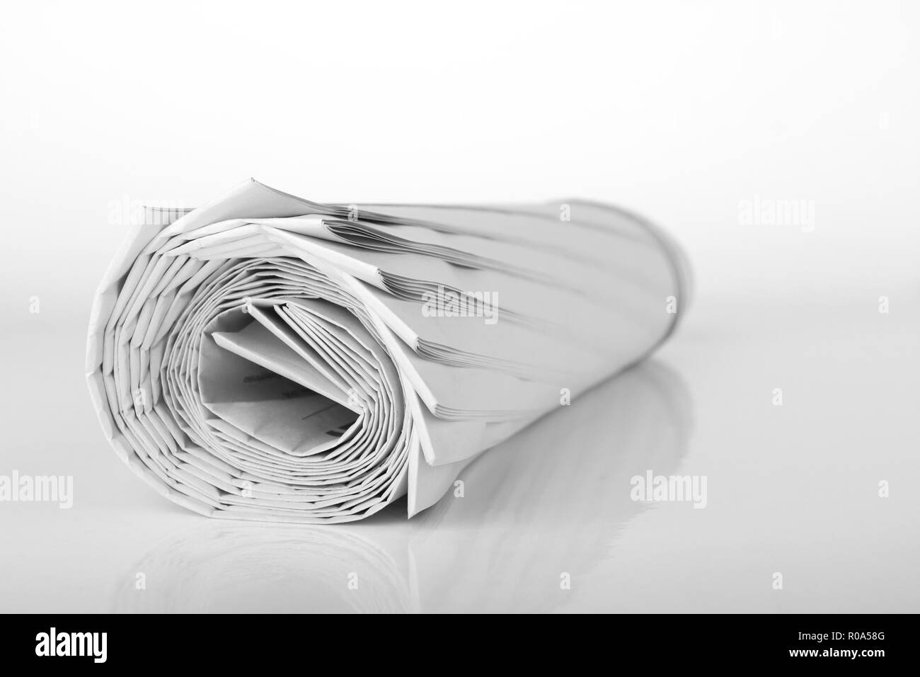 Roll of newspaper isolated on white background Stock Photo - Alamy