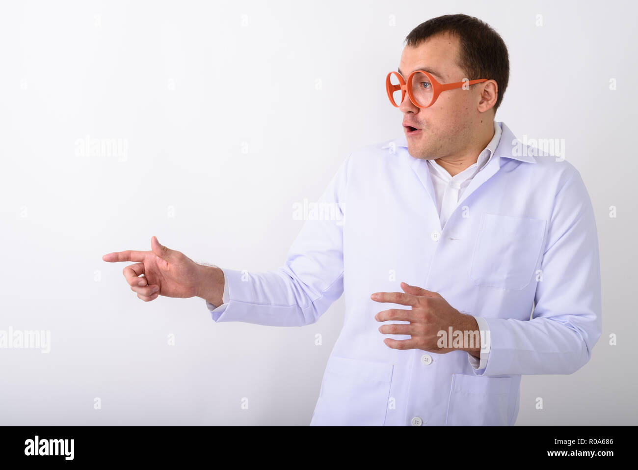 Studio shot of young muscular man doctor pointing to the side wh Stock ...