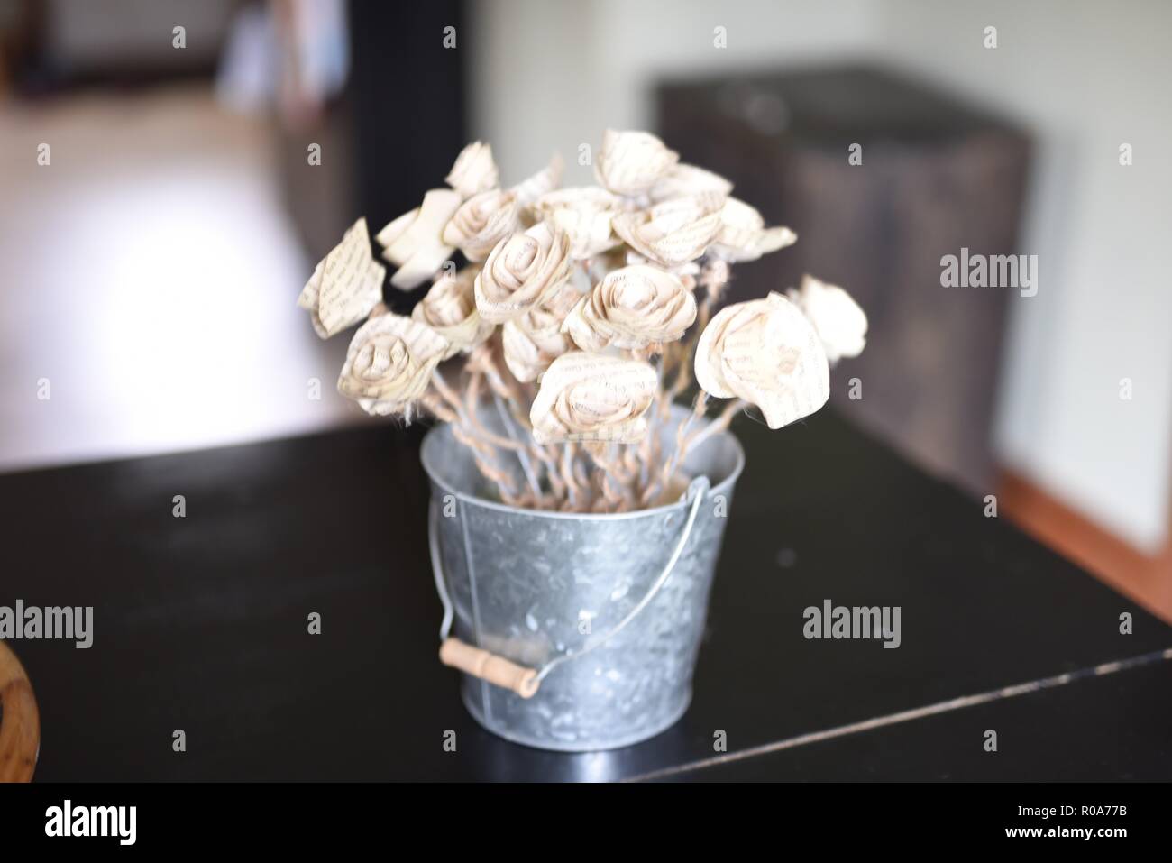 Paper flowers made out of old book pages, in a gray tin bucket ...