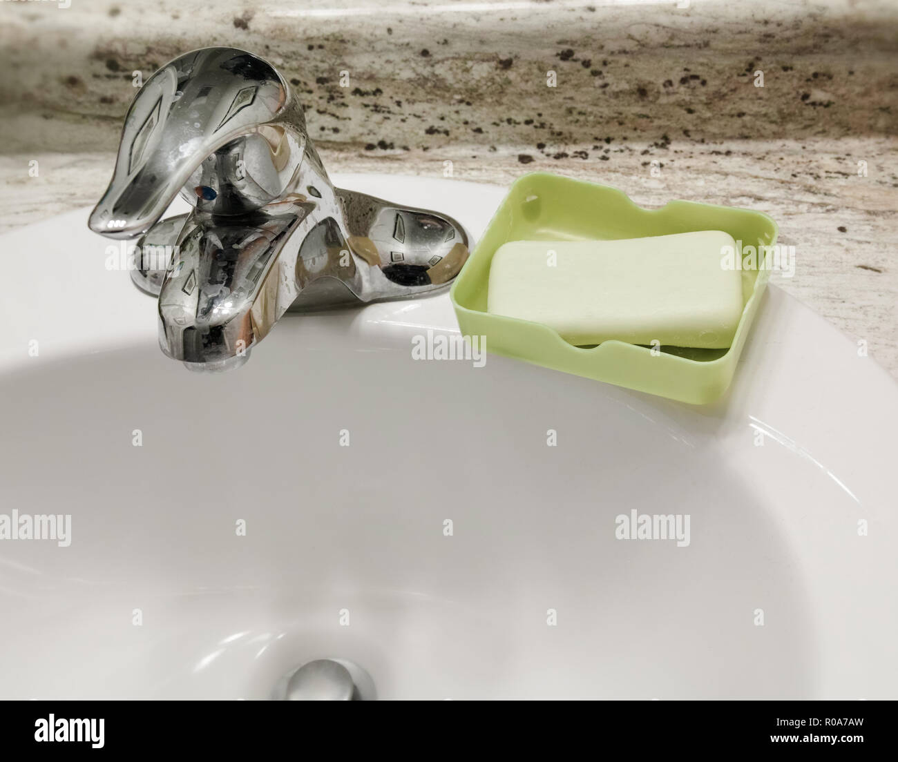 On the side of the sink and next to the tap, a soap bar in the soap ...