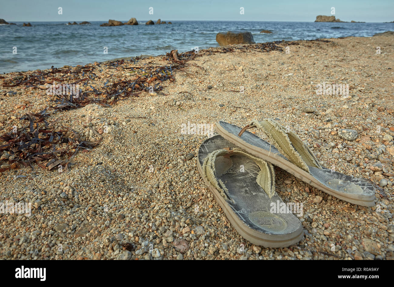 Symbol of peace and solitude: pair of worn and worn slippers abandoned ...