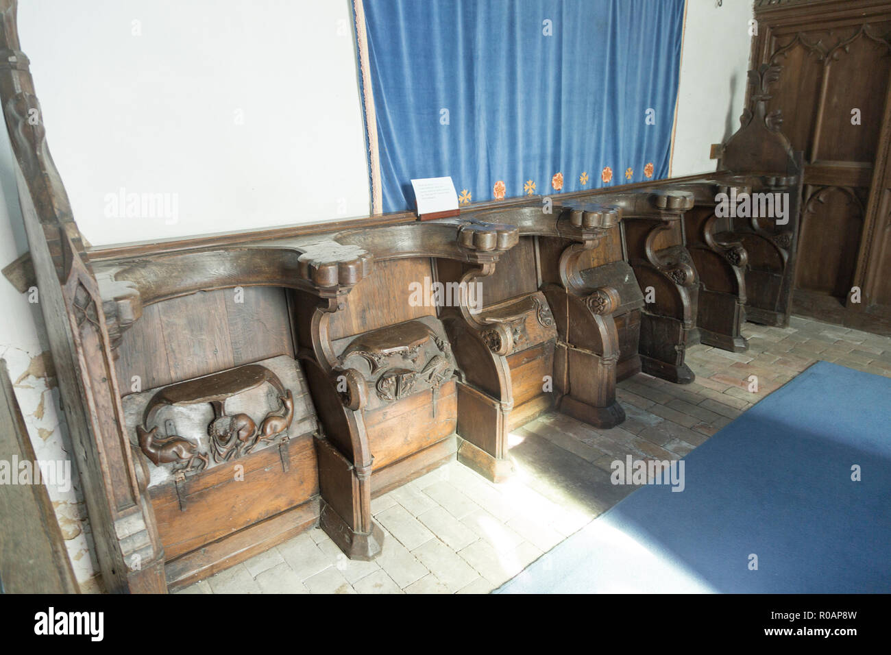 Carved decorated wooden misericord seats in church at Framsden, Suffolk ...
