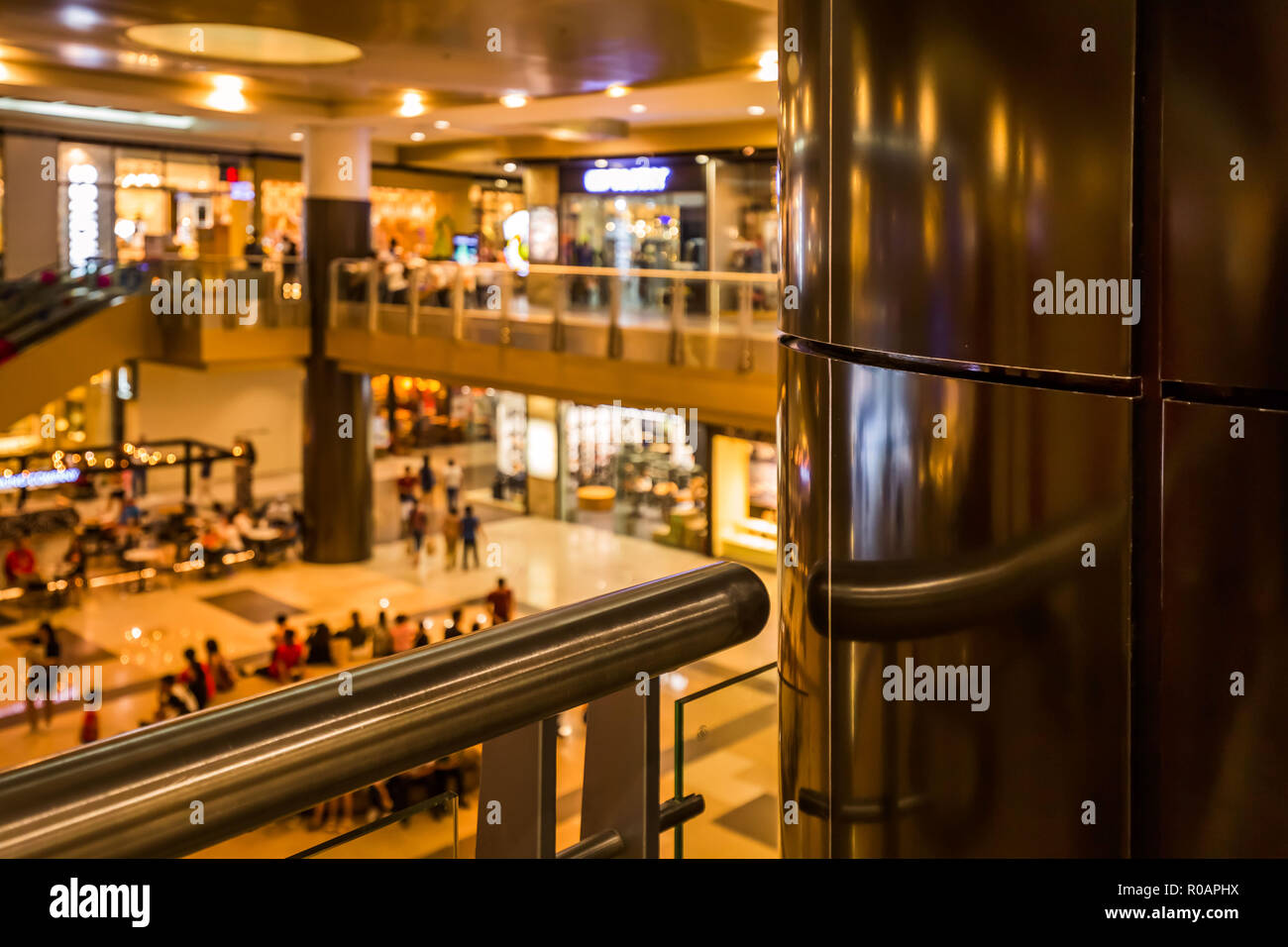 Handrail and light reflection in a shiny column in a shopping mall with ...
