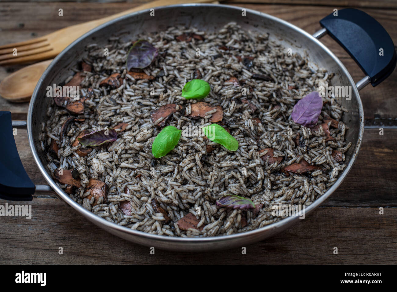 Italian homemade black risotto with squid on pan Stock Photo - Alamy