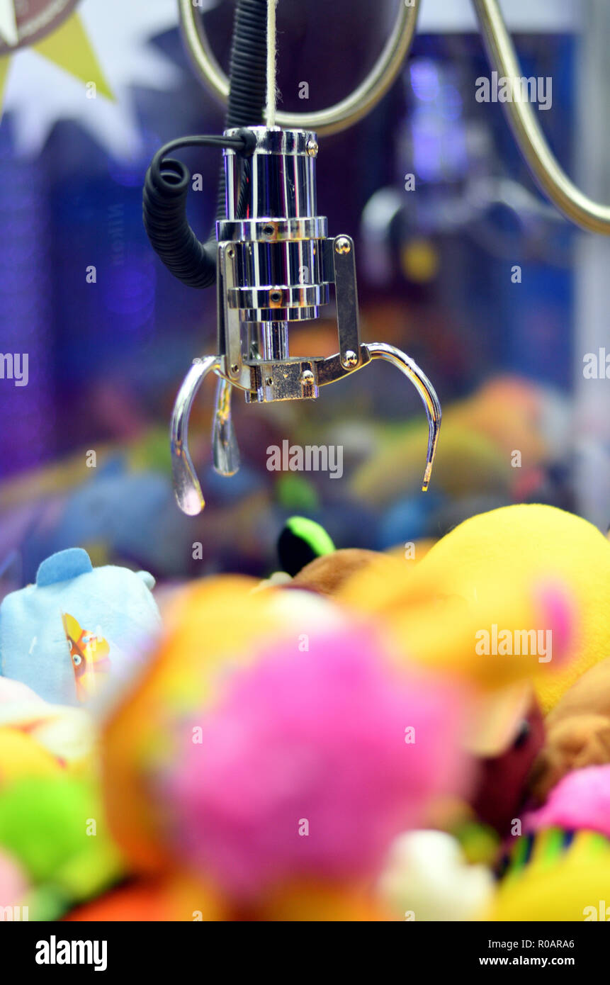 Gripper arm of an automatic gripper in action UFO Catcher Stock Photo ...