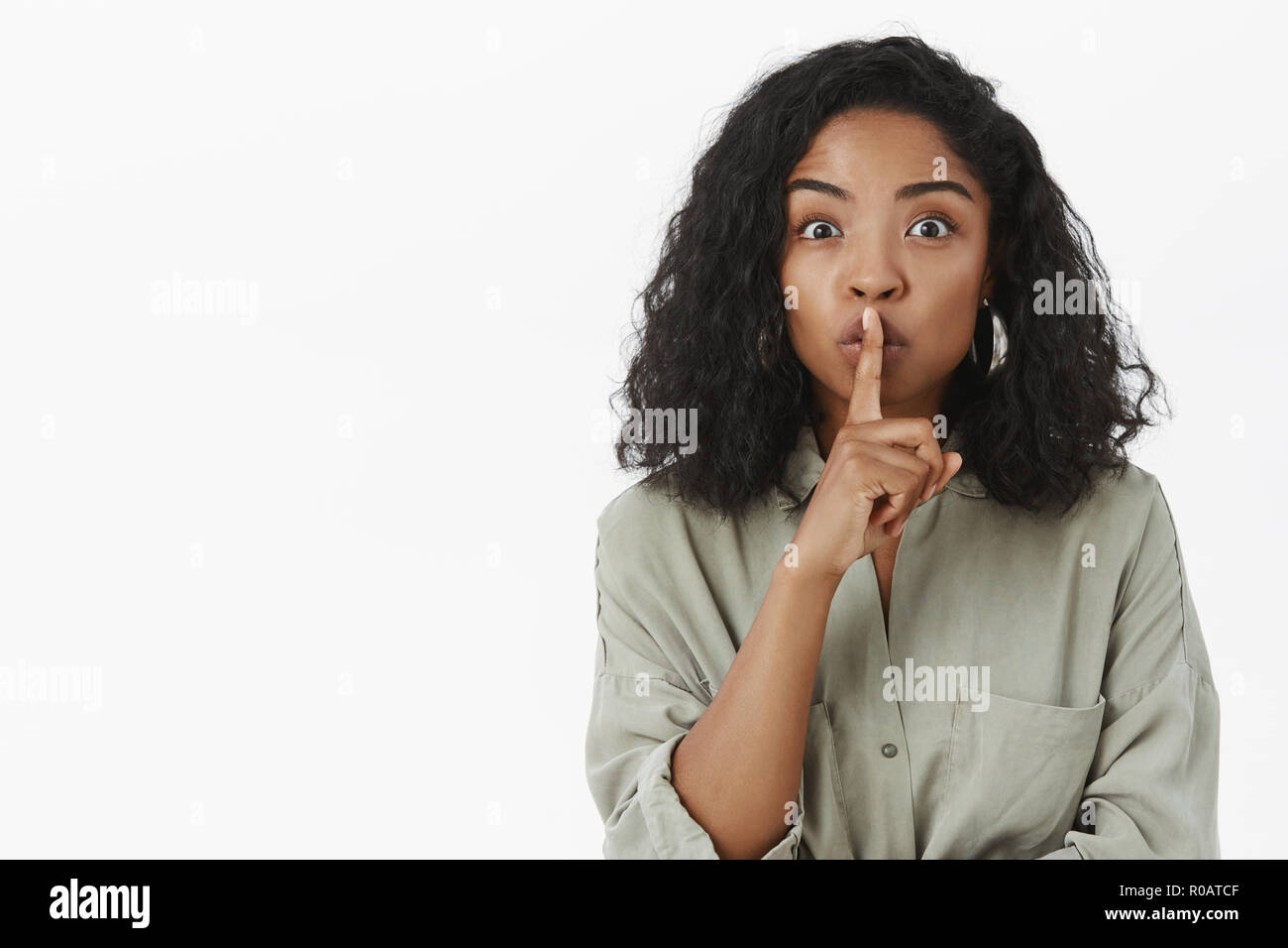 Talkative attractive african american woman in trendy shirt with curly ...