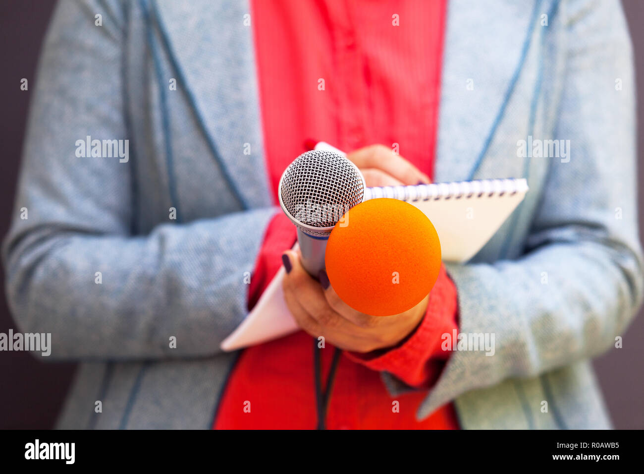 A female journalist during press conference, taking notes and holding ...