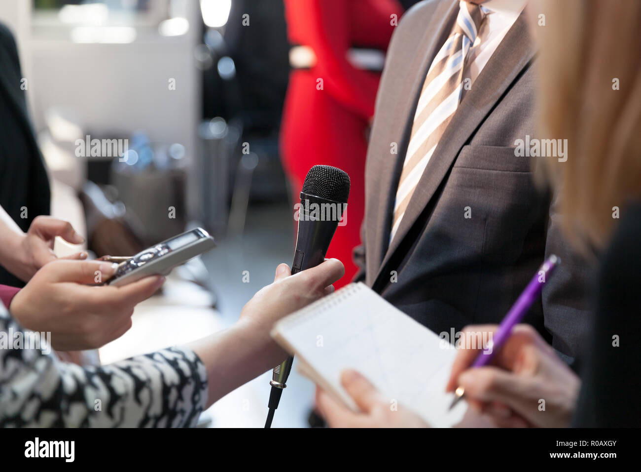 Press conference - one reporter holding microphone, other journalist ...