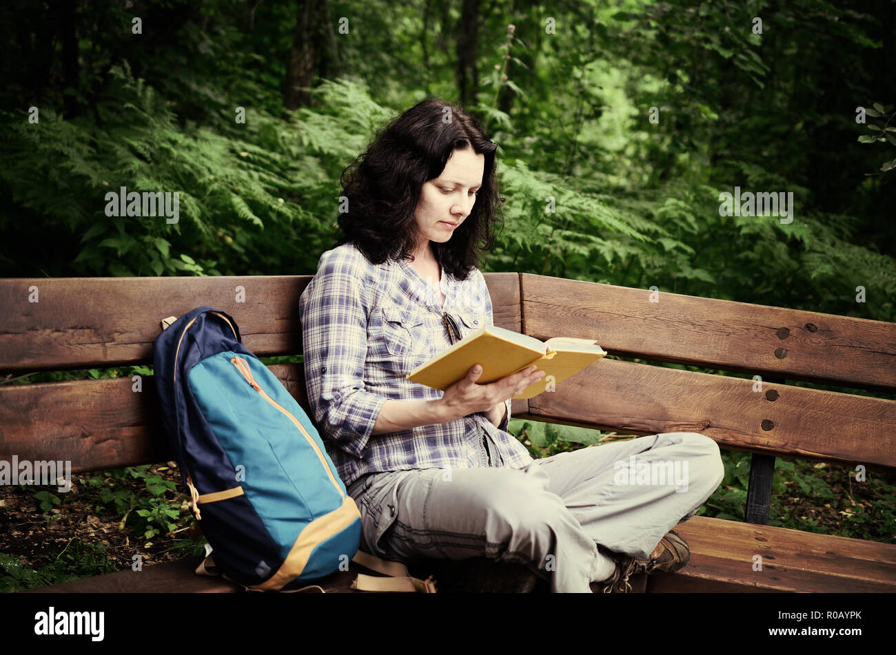 Traveling woman reading book and relaxing at park. Concept of freelance ...