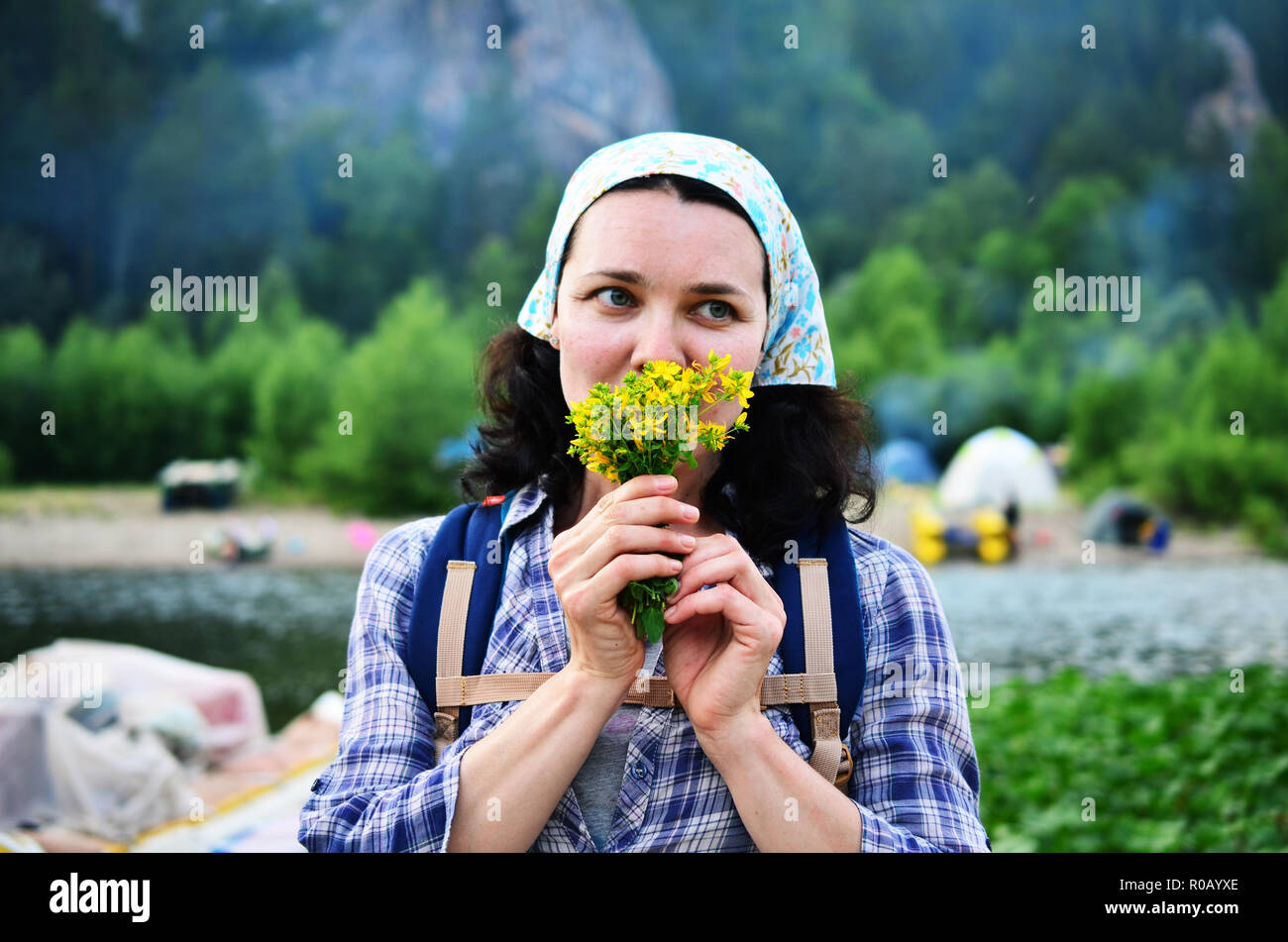 Traveling girl smells yellow flowers taken from nature on background of ...