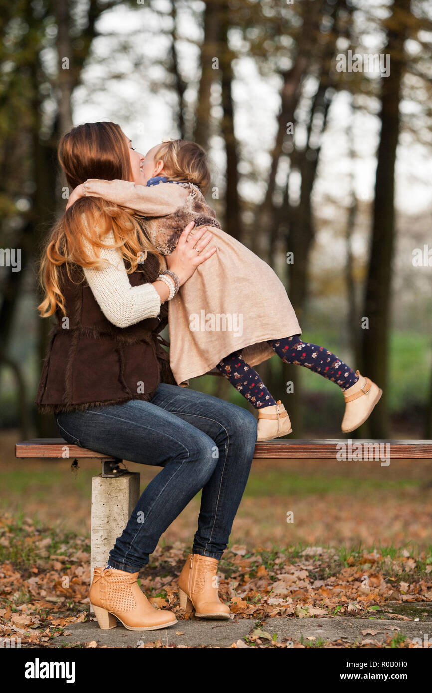 Mother and daughter on bench in park Stock Photo - Alamy