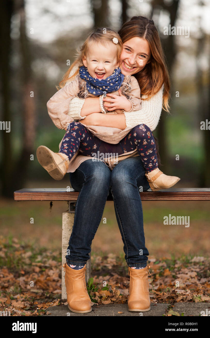 Mother and daughter on bench in park Stock Photo - Alamy
