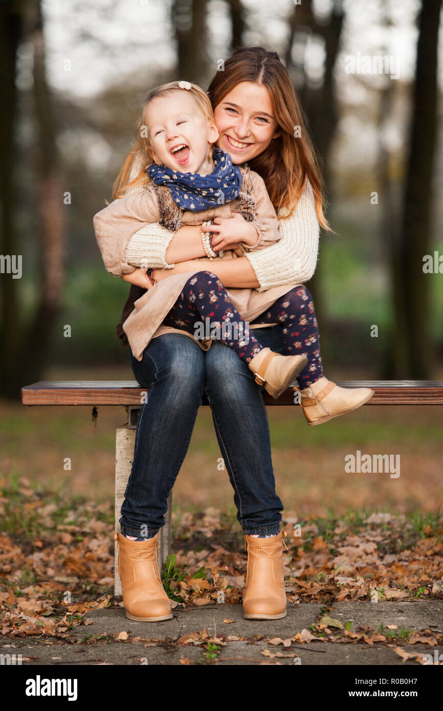 Mother and daughter on bench in park Stock Photo - Alamy