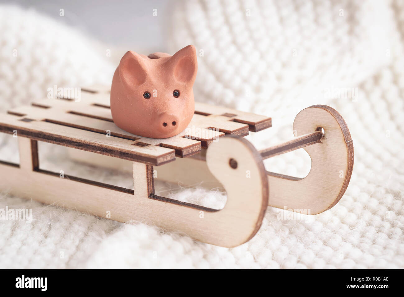 Symbol of the year by the horoscope, small clay pig on a wooden sled ...