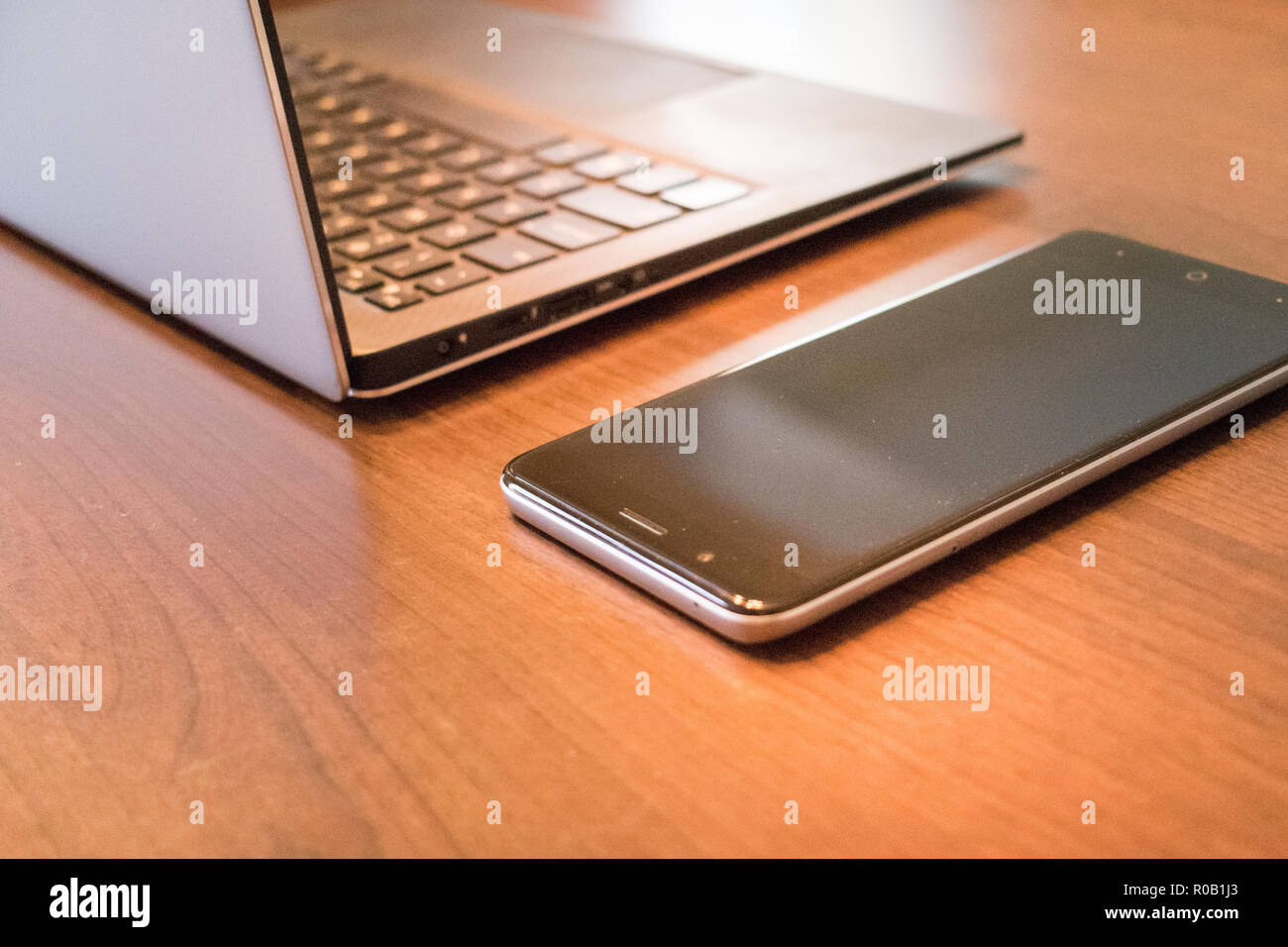Modern laptop on a table with phone Stock Photo - Alamy