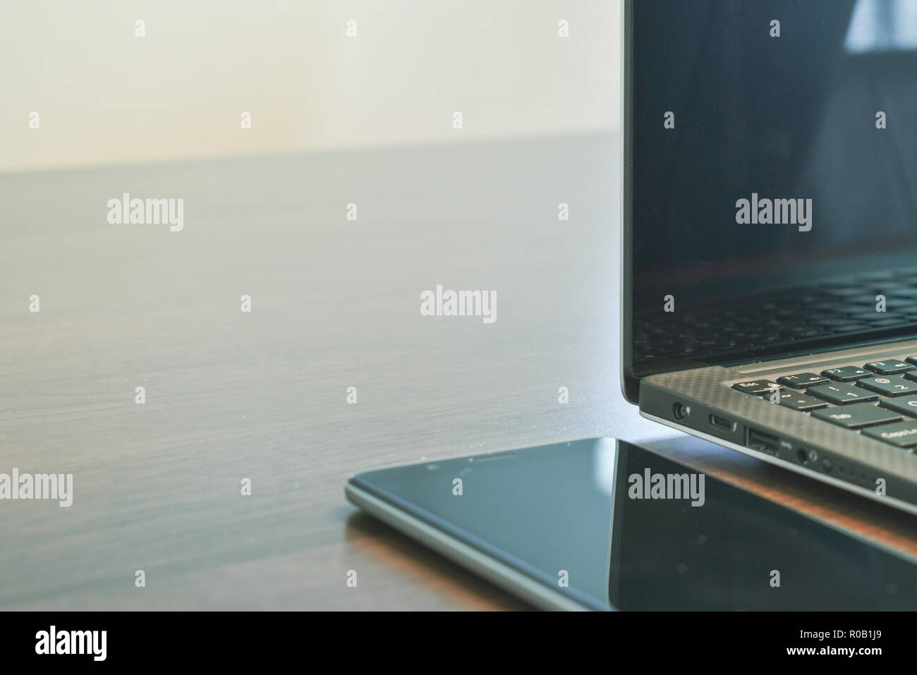 Modern laptop on a table with phone Stock Photo - Alamy