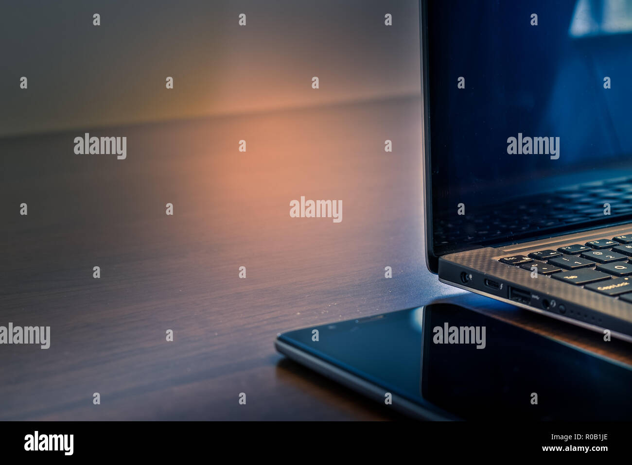 Modern laptop on a table with phone Stock Photo - Alamy