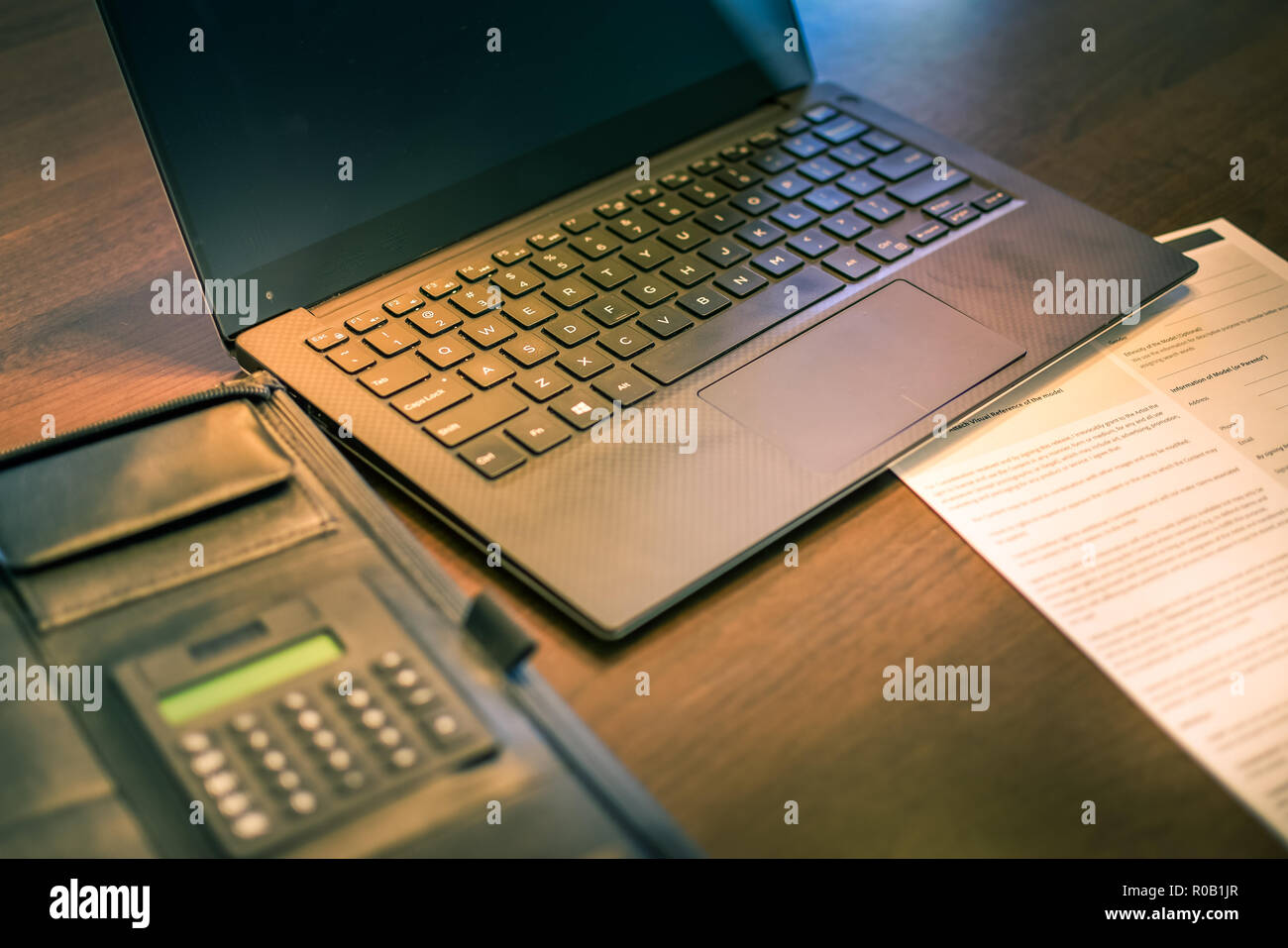 Modern laptop with paperwork on a desk Stock Photo - Alamy
