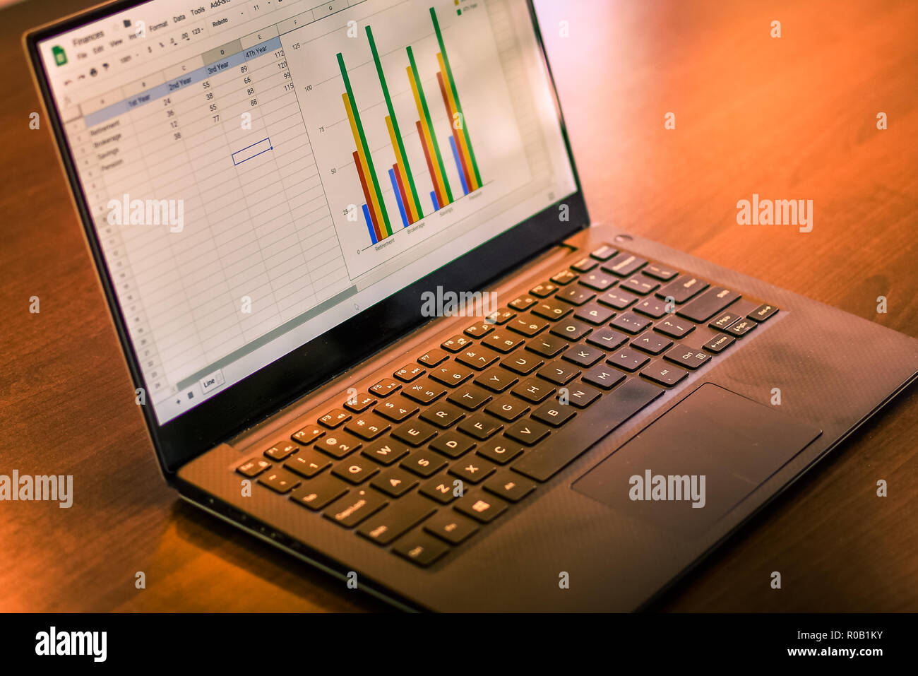 Computer with graph background on a desk Stock Photo - Alamy