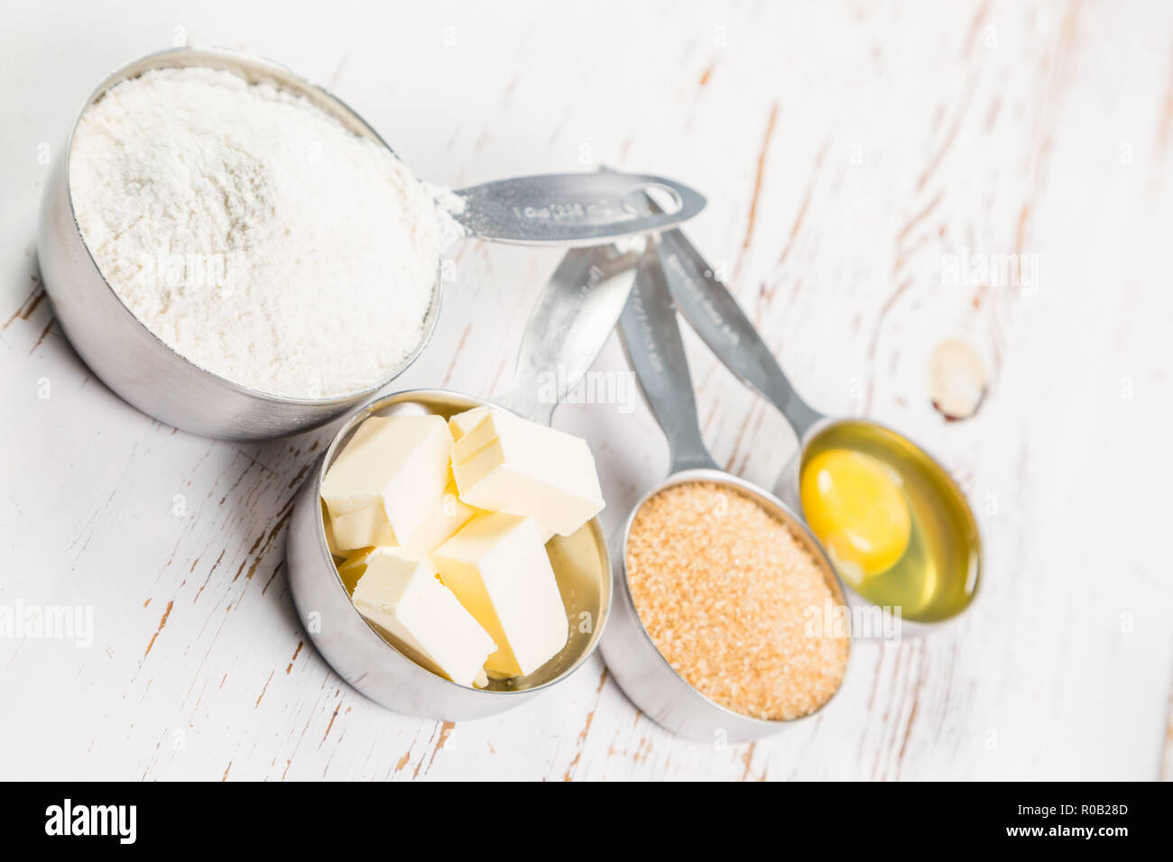 Baking ingredients in measuring cups, white wood background Stock Photo ...