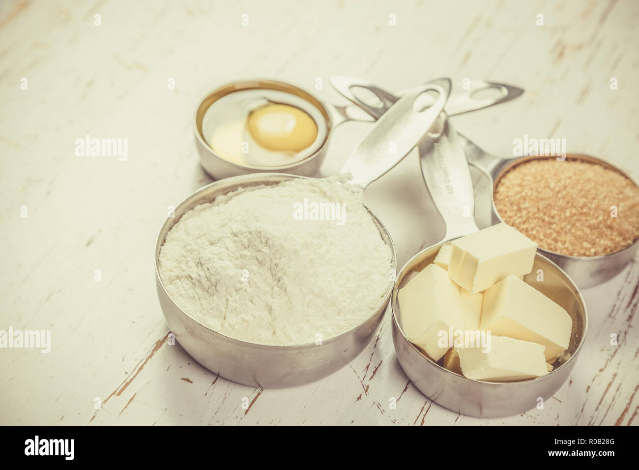 Baking ingredients in measuring cups, white wood background Stock Photo ...