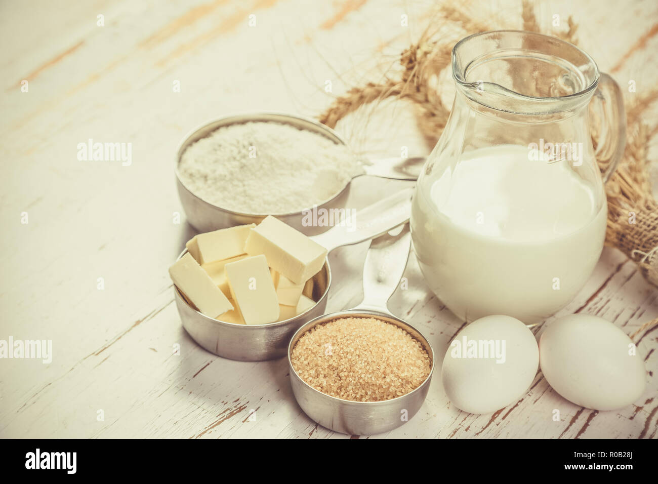 Baking ingredients in measuring cups, white wood background Stock Photo ...