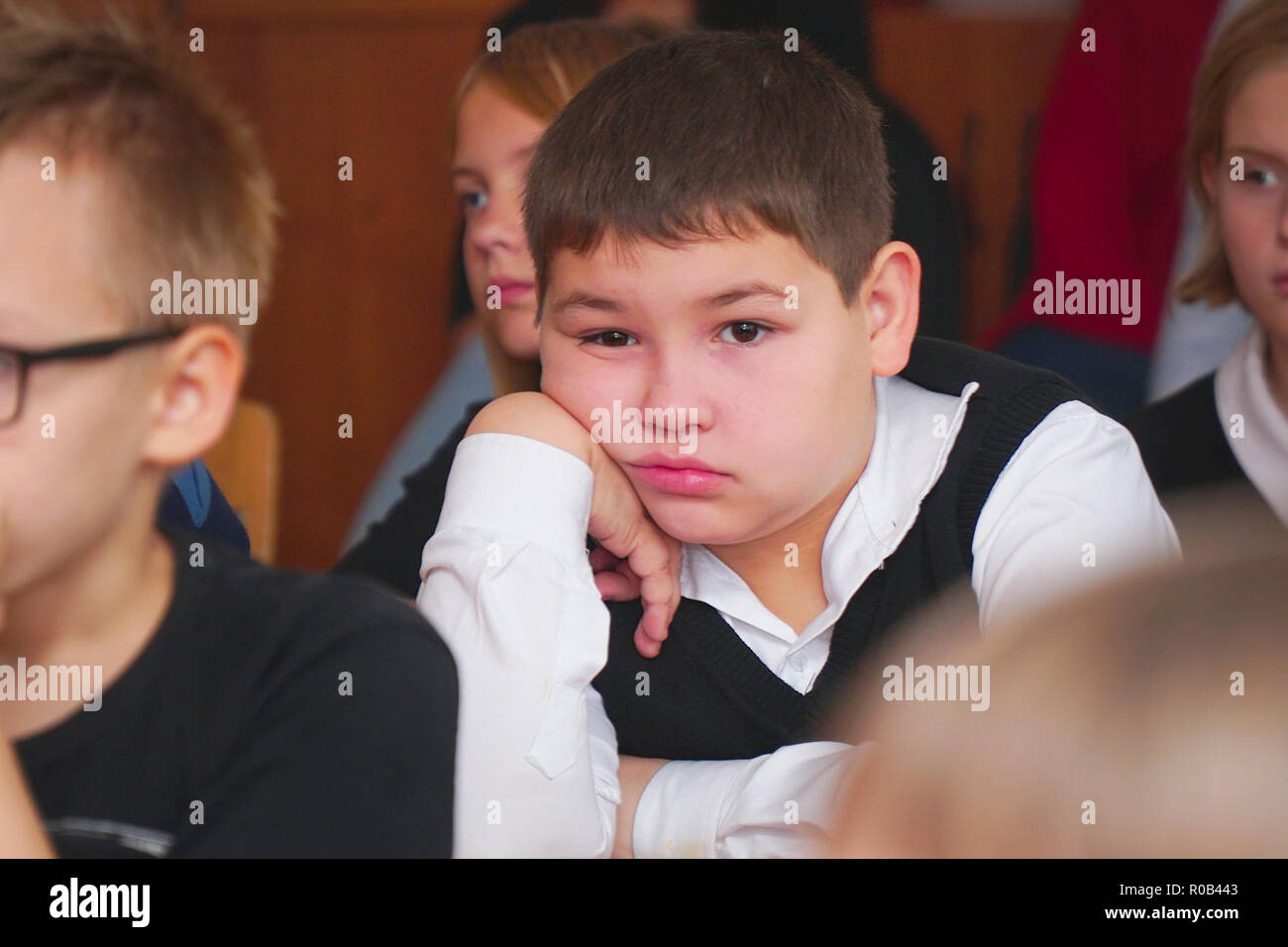 Schoolboy in class listening to the teacher Stock Photo - Alamy