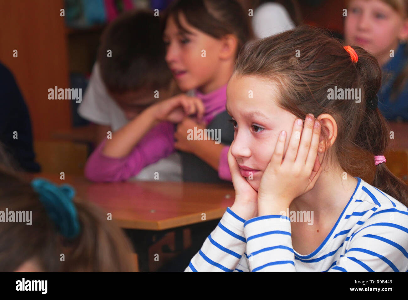 Schoolgirl in the classroom listening to the teacher Stock Photo - Alamy