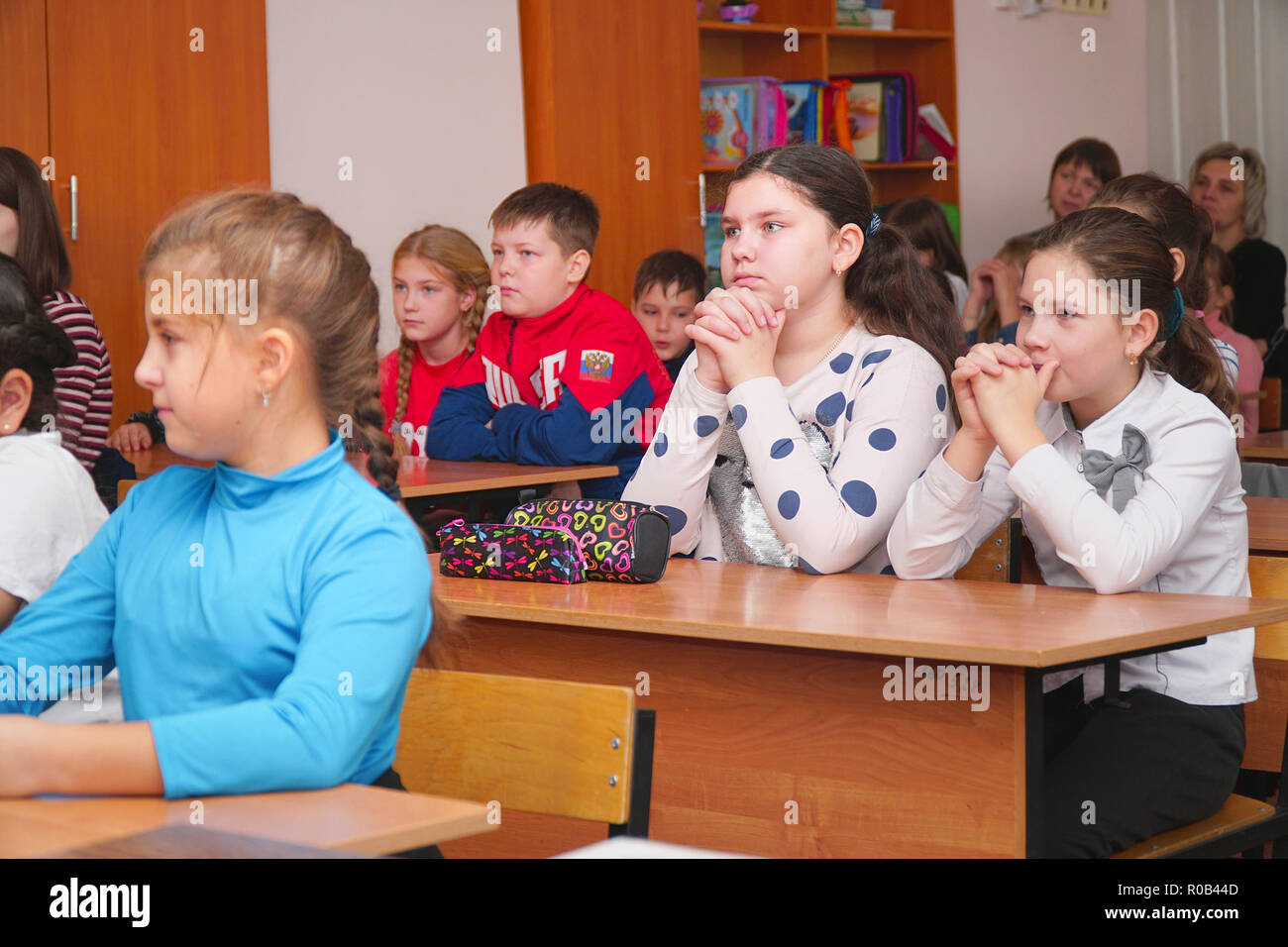 Schoolkids in the classroom listen to the teacher Stock Photo - Alamy