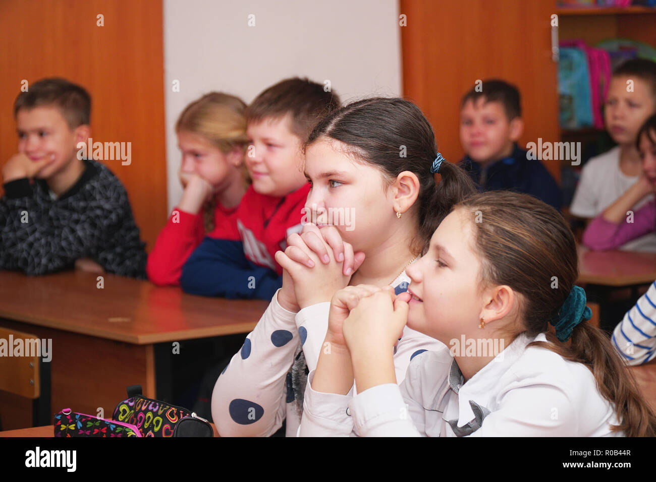 Two girls in the classroom listening to the teacher Stock Photo - Alamy